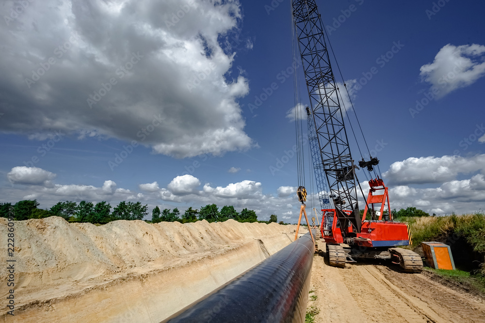 Bau einer Gaspipeline - mehrere Kräne hieven die Rohrleitung einer ...