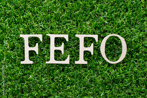 Wood letter in word FEFO (first expired first out) on artificial green ...