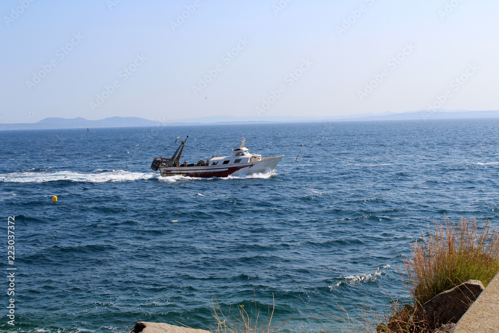 paysage de la côte ou front de mer Roses en Espagne avec chalutier ...