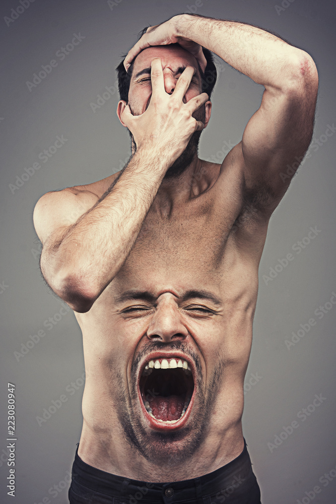 Tortured man, pain and insanity concept: man screaming with face ...