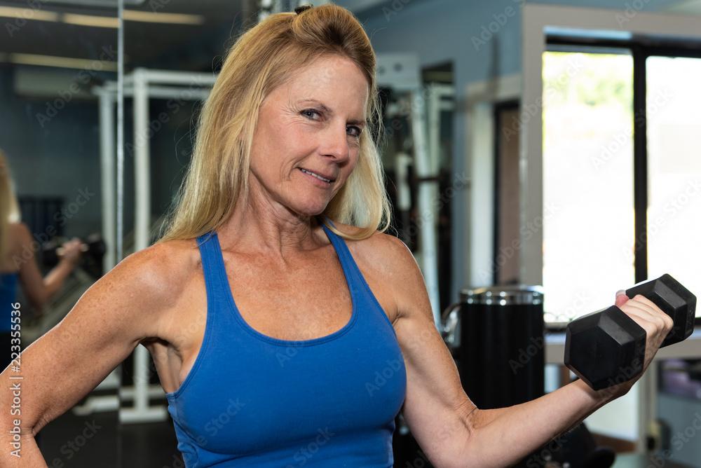 Female middle age fitness model shows muscular and lean arm strength ...