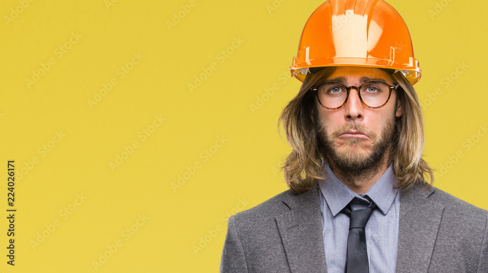Young handsome architec man with long hair wearing safety helmet over ...