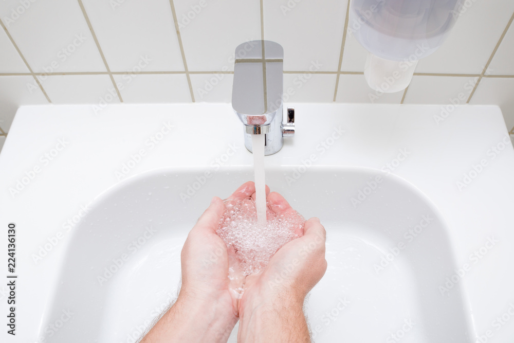 Young man washing hands under the water tap. Water running. White ...