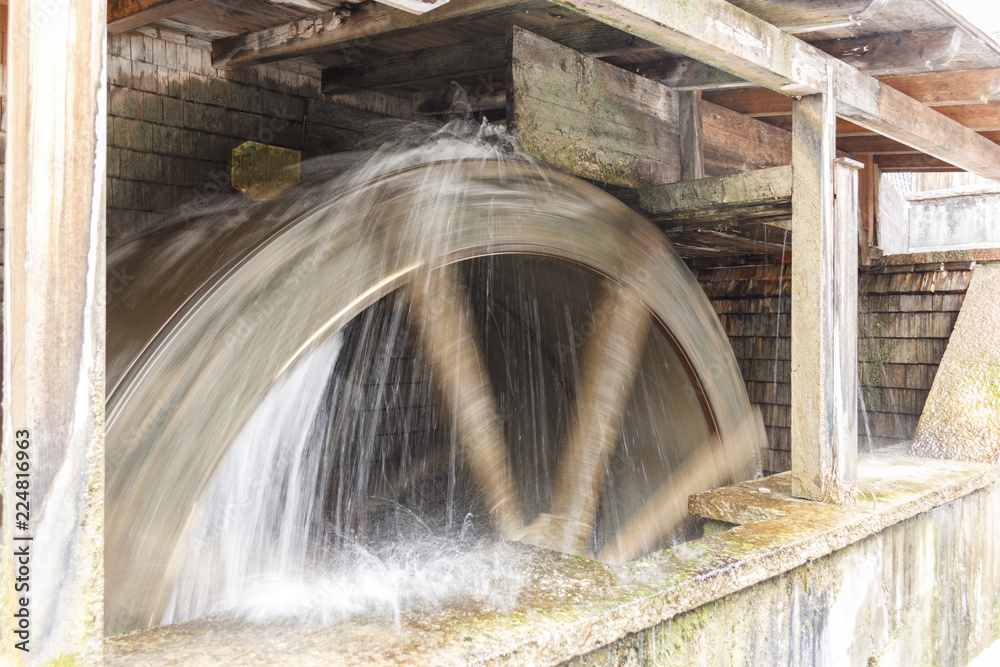 ancient, vintage wood working watermill wheel at which water flows ...