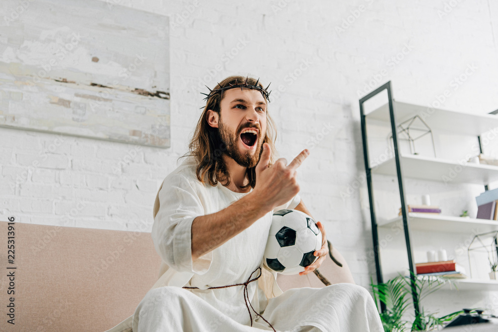 angry Jesus in crown of thorns showing middle finger during watching of ...