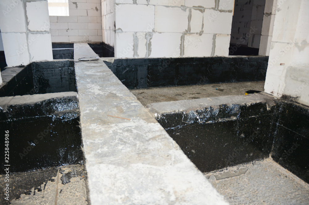 Foundation bitumen waterproofing. Building house construction with ...