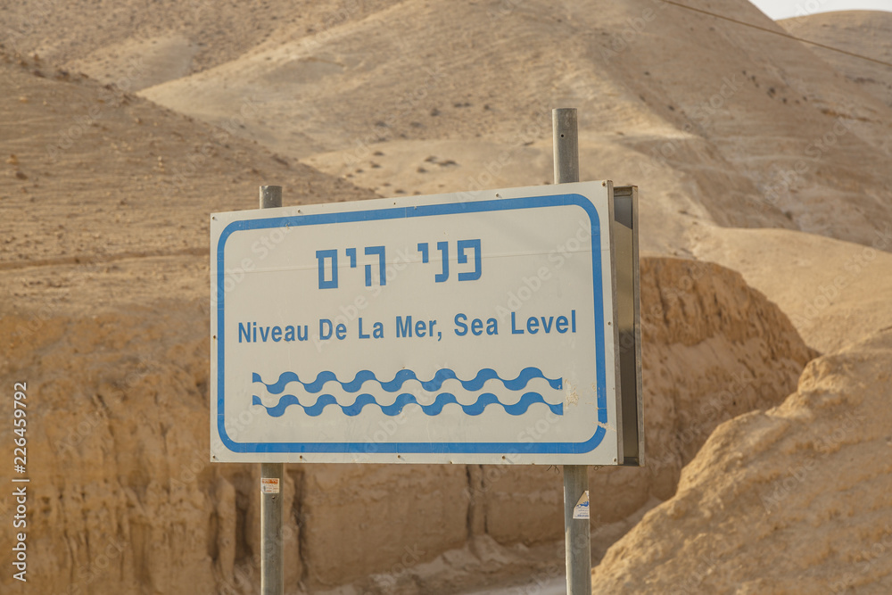Sign indicating sea level on the road going down to the dead sea ...