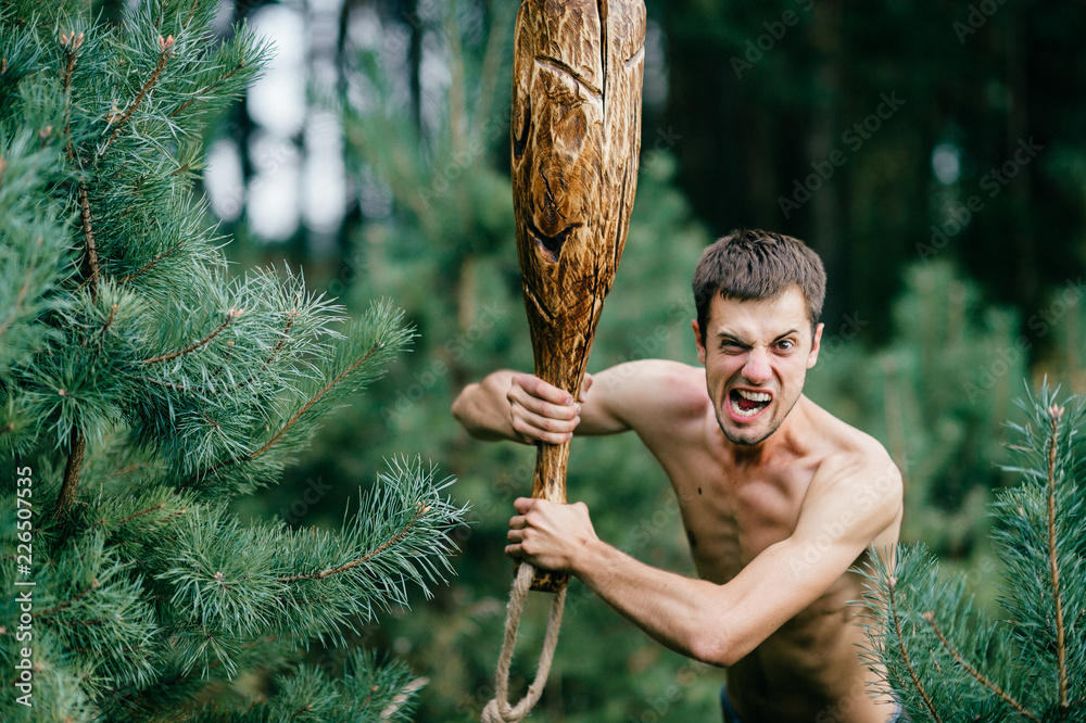 Foto de Stock Odd primitive naked man with huge wooden stick hunting in ...