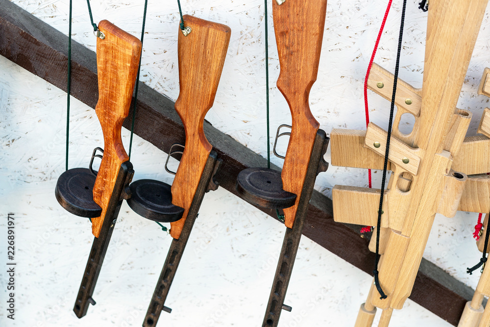 Hanged wooden thompson machine gun and automatic rifle toys at counter ...