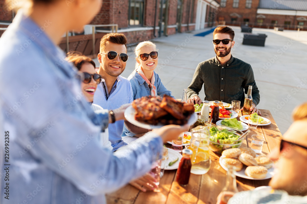 leisure and people concept - happy party host offering meat to his ...