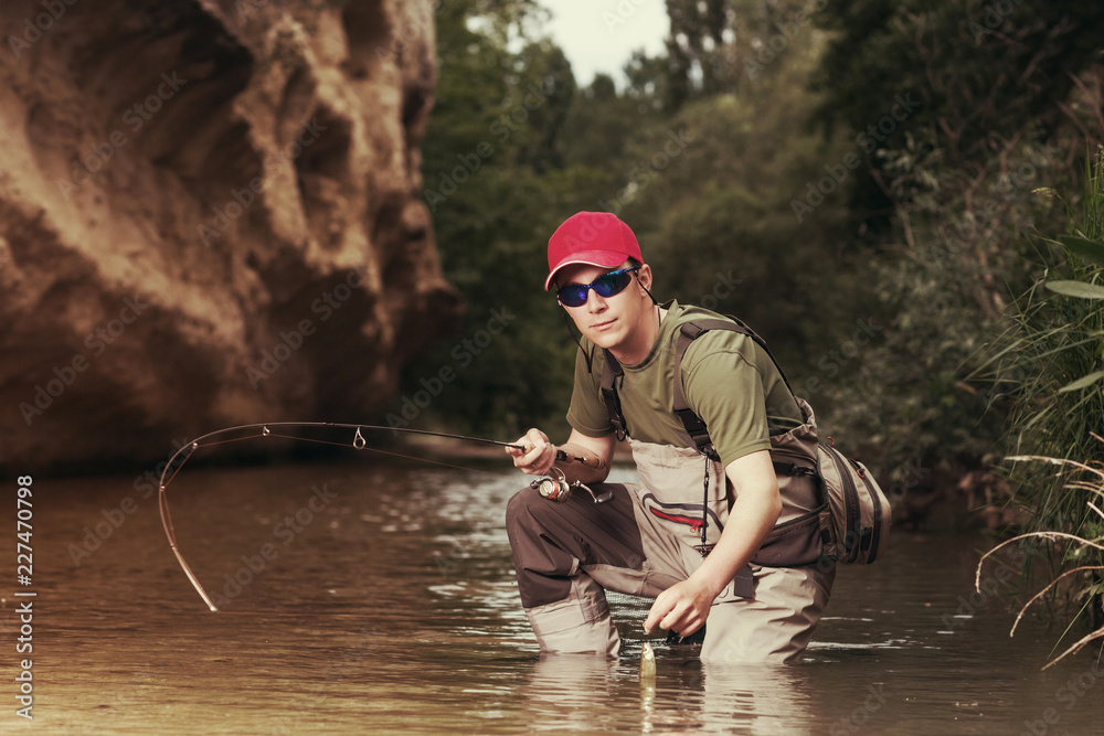 Fisherman caught a fish pulled from the water. Trout fishing on the ...