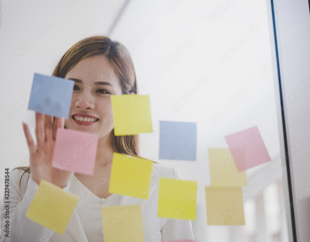 Business woman is writing idea on to post it windows for plan Stock ...