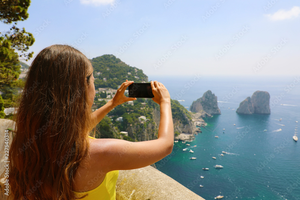 Beautiful girl taking picture in Capri Island with Faraglioni sea stack ...