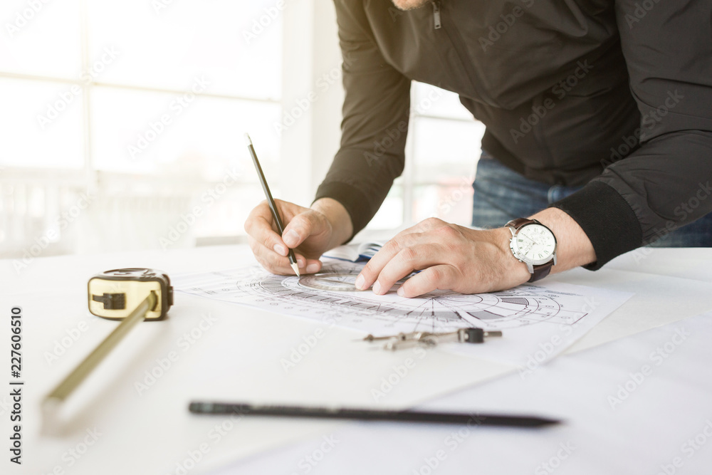 architect builder works at the table with drawings. Helmet, drawings ...