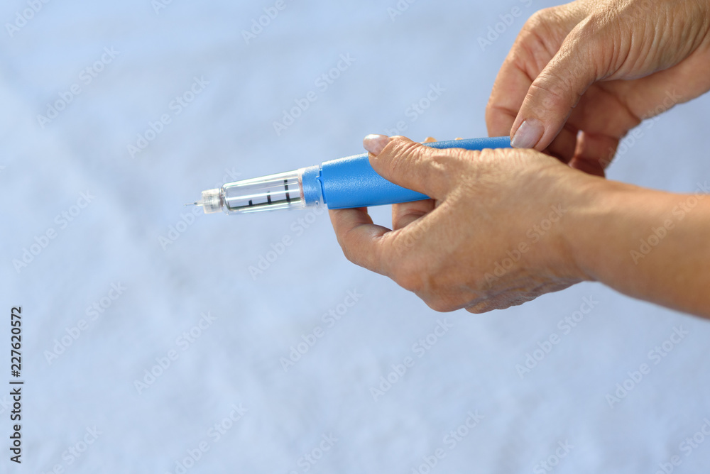 Stock-Foto „Elderly woman giving herself injection against osteoporosis ...