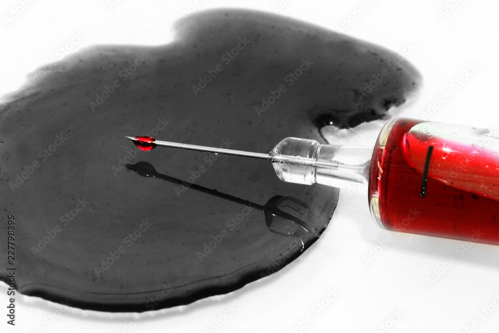 Isolated syringe have red blood inside with needle and some blood drop ...