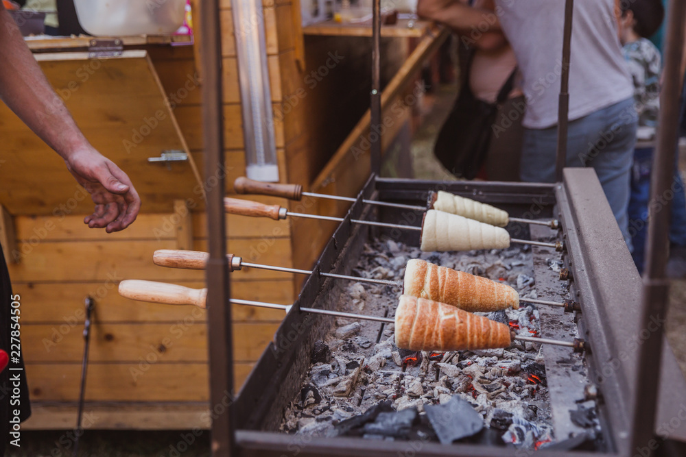 The baking of Kurtoskalacs, the traditional hungarian spit cake, in a ...