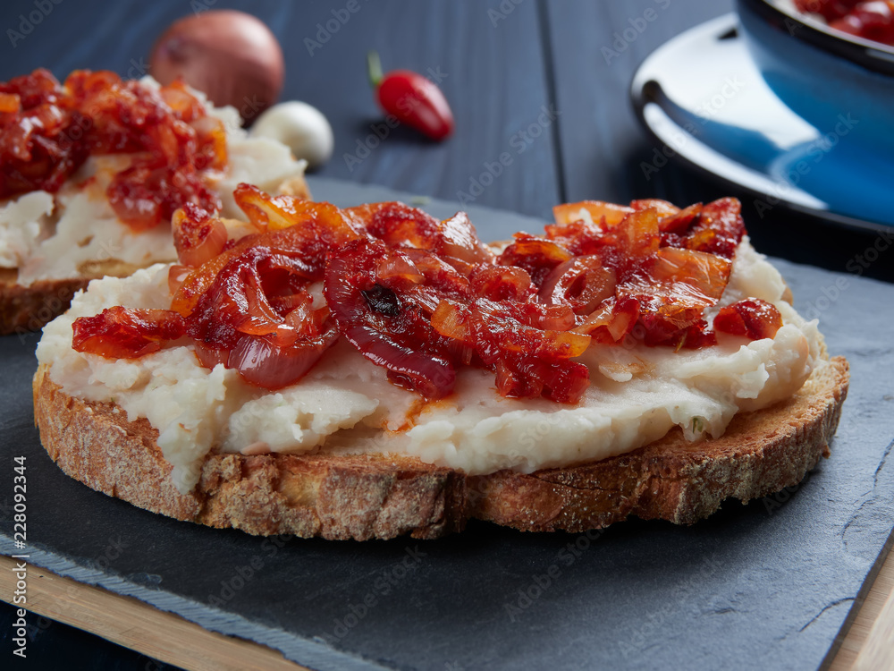 Mashed beans spread with garlic vegetable oil, with a topping of ...