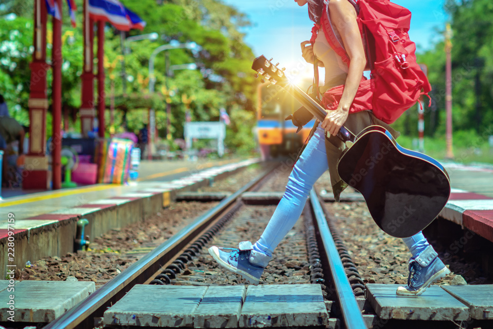 young woman running across railway at risk of the incoming train to ...