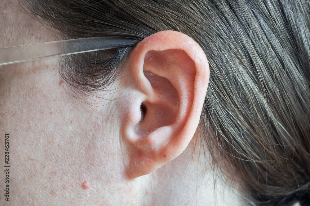 Ear and auricle, part of cheek, hair, skin and glasses. Body part. Side ...