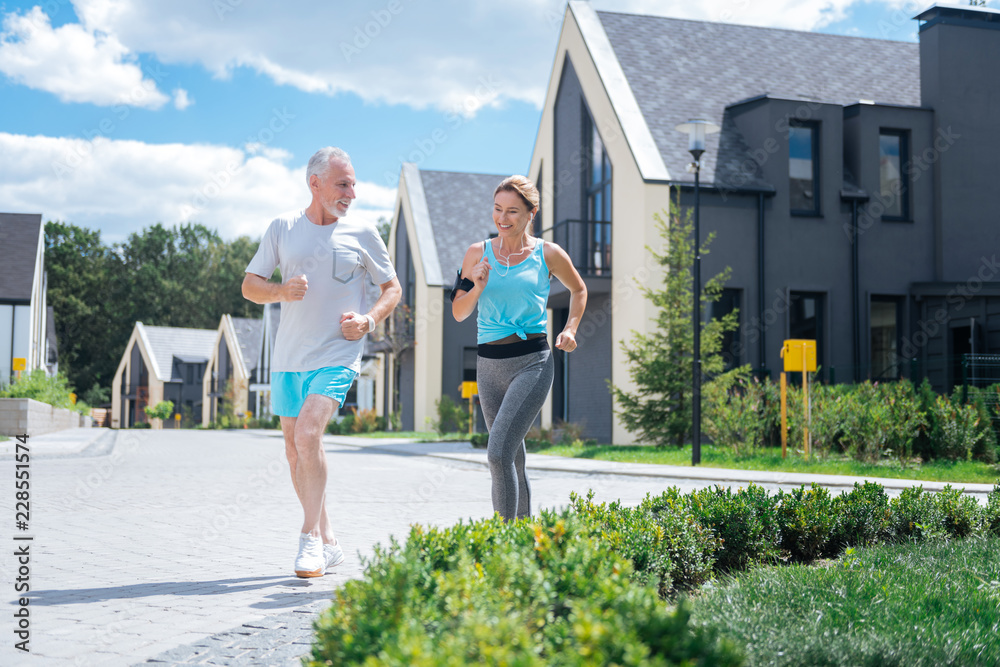 Running with music. Modern beautiful woman listening to music using ...