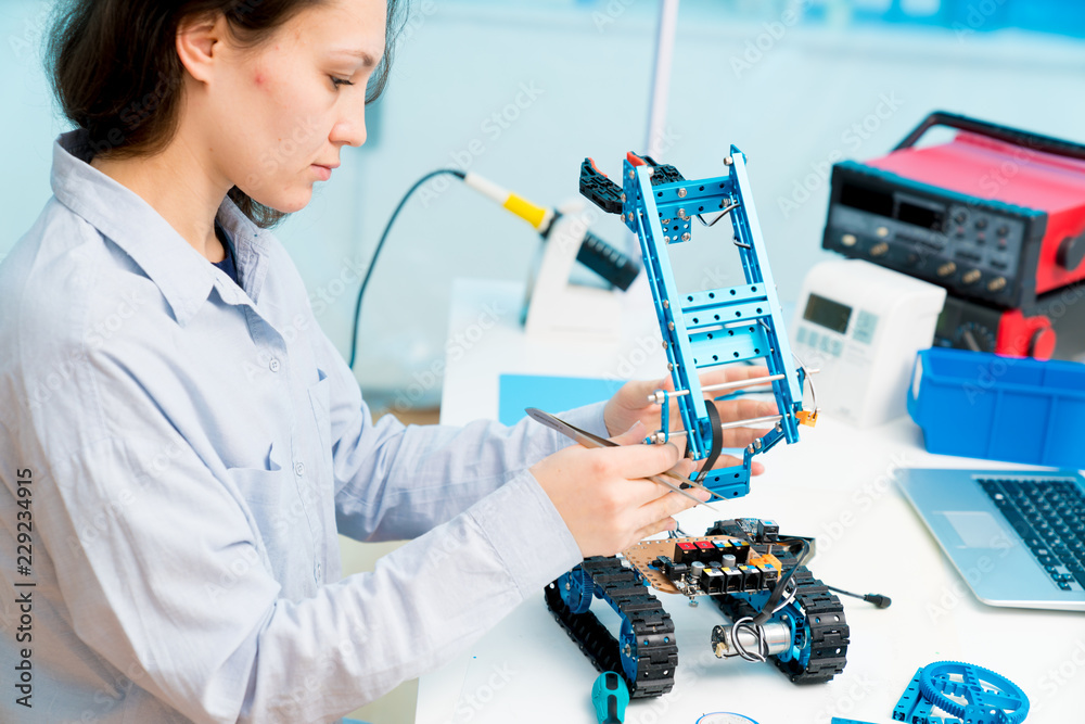 Student girl in electronics laboratory, experiment with microcontroller ...