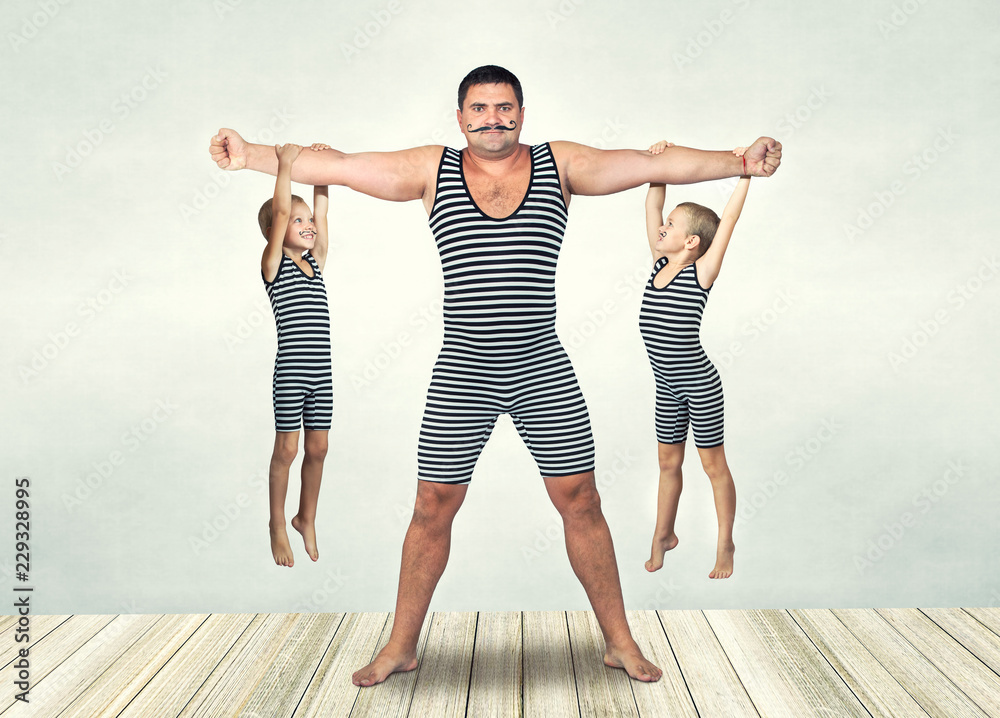 Family of strongman. The father of two sons in vintage costume of ...
