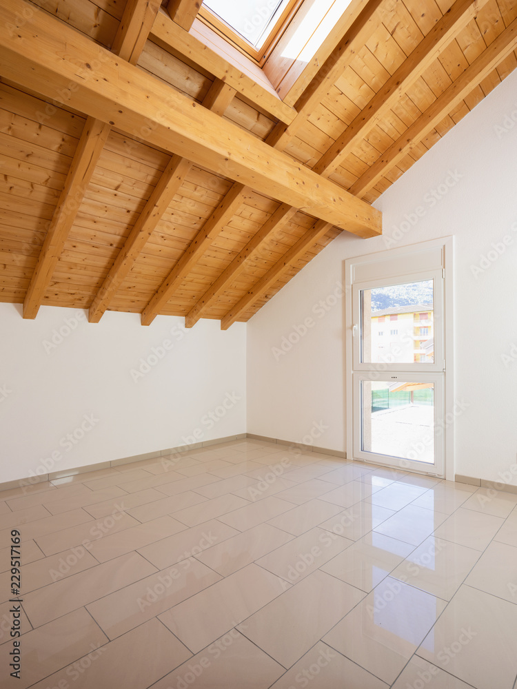 Empty room with a sloping roof and wooden beams Stock Photo | Adobe Stock