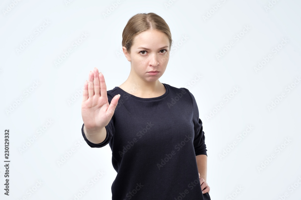 Serious pretty woman making stop hand sign palm gesture, isolated over ...