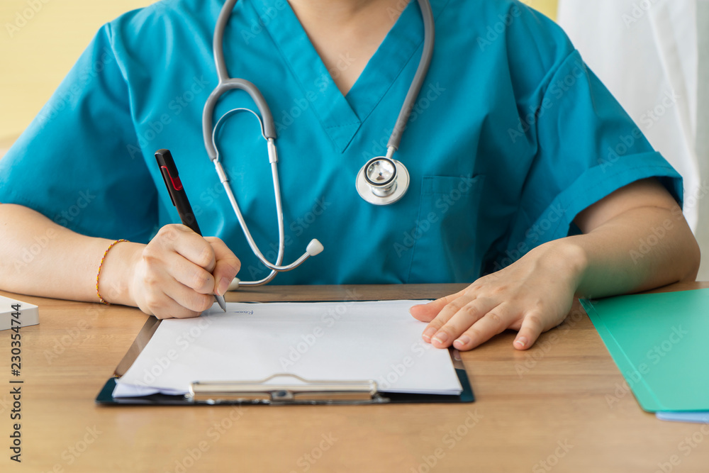 Doctor or Nurse signing a medical report or writing on medical health ...