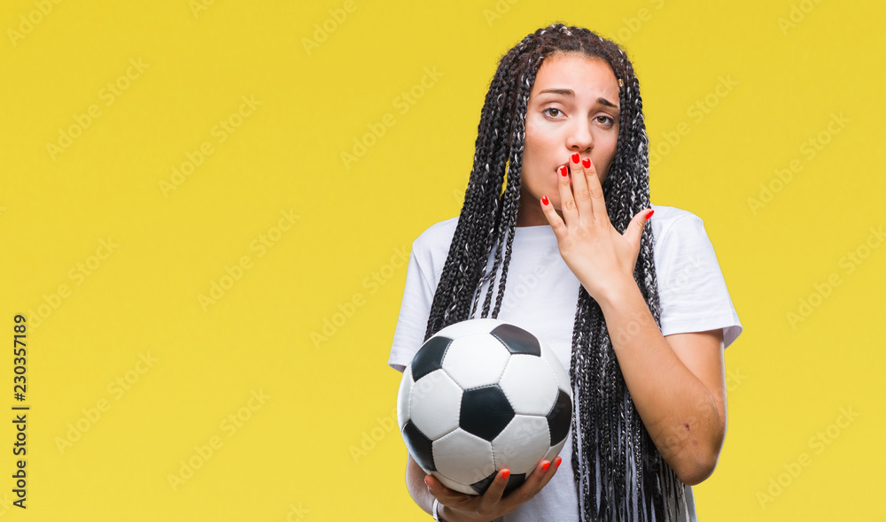 Young braided hair african american girl holding soccer ball over ...