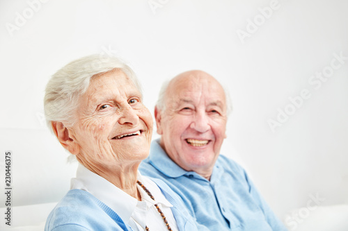 Glückliches Rentner Paar sitzt auf dem Sofa foto de Stock | Adobe Stock