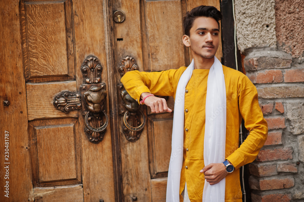 Indian stylish man in yellow traditional clothes with white scarf posed ...