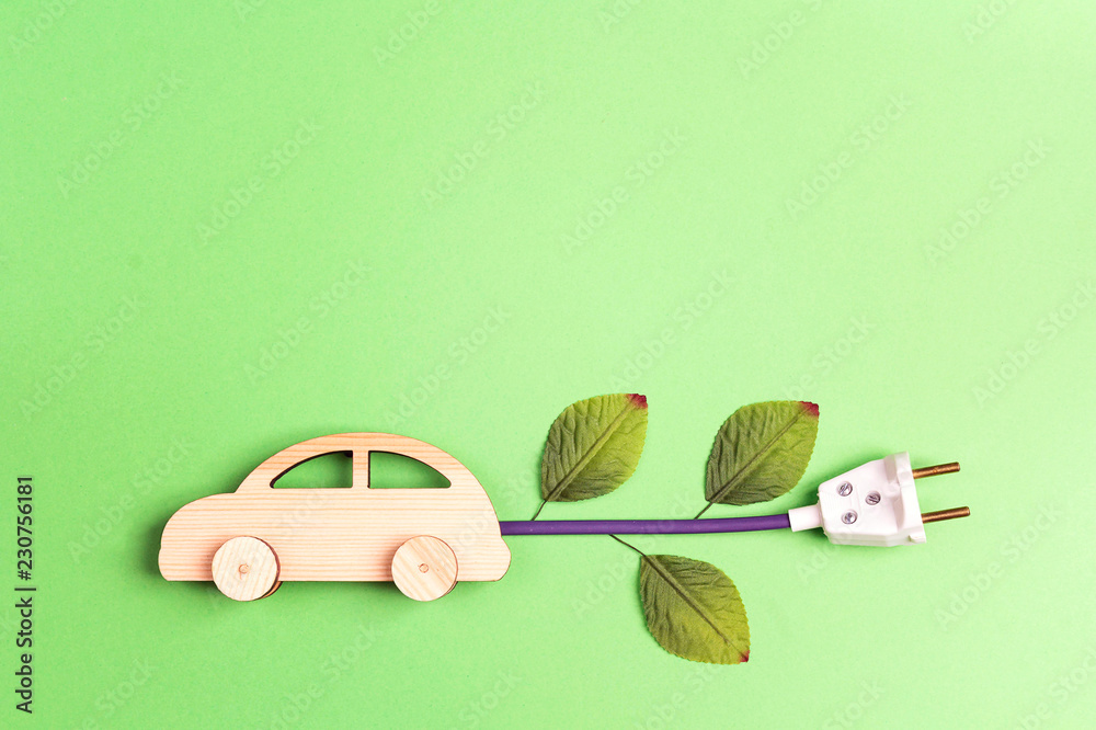Wooden toy car with electrical cable plug as an electric car symbol ...