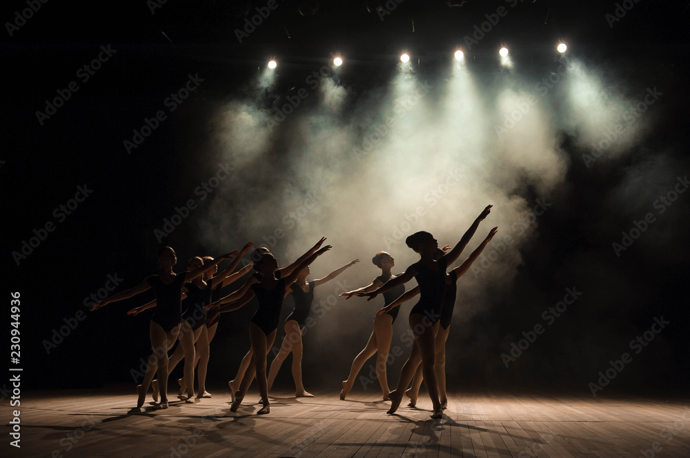 Ballet class on the stage of the theater with light and smoke. Children ...