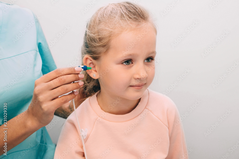doctor check a girl's ears. Little girl having hearing test , procedure ...