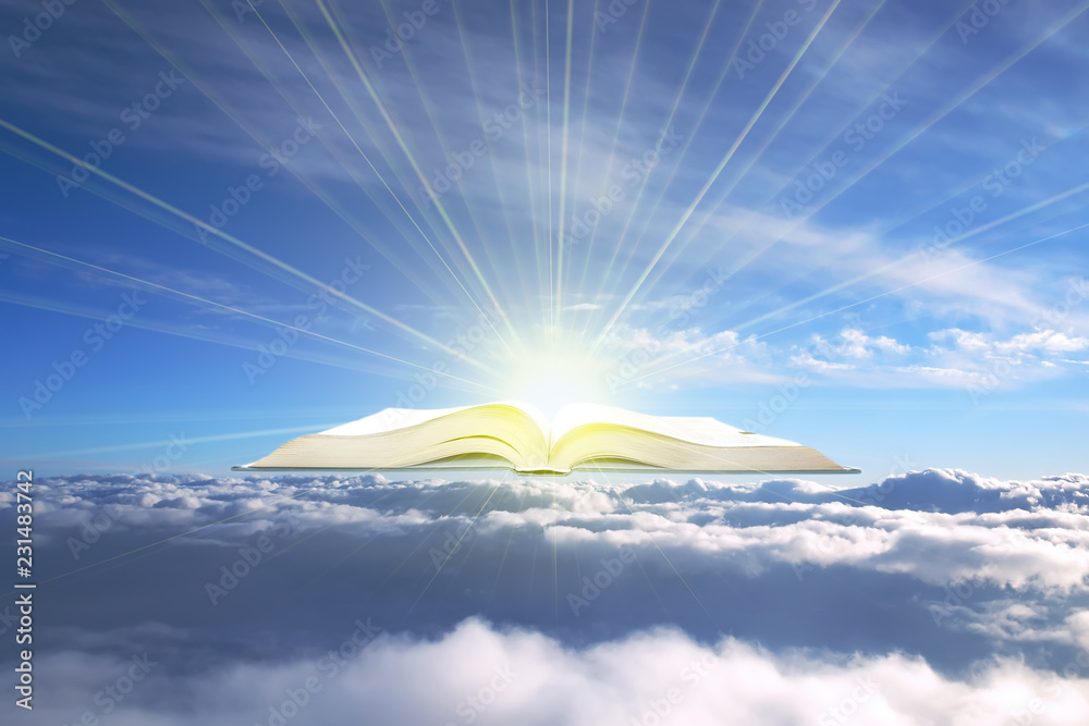 holy book Bible above the clouds in the rays of bright sacred radiance ...