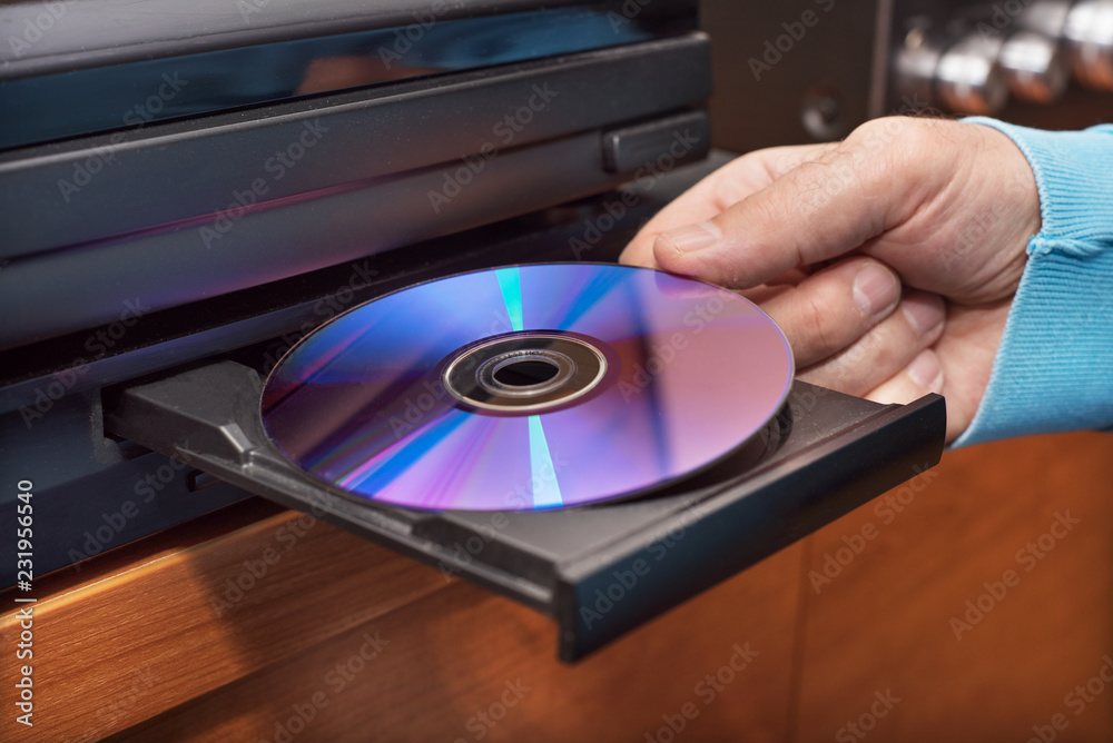 Hand holding DVD inserting to video player Stock Photo | Adobe Stock