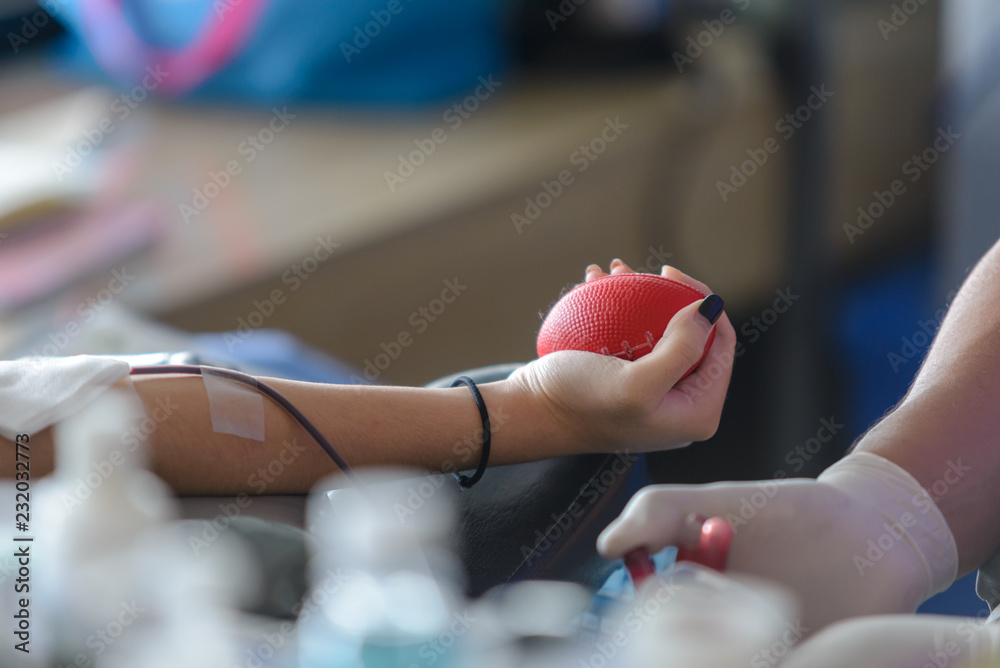 Close up right arm of asian female receiving blood and holding rubber ...