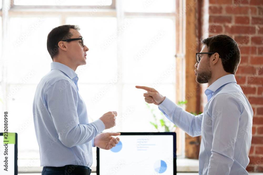 Mad male colleagues have disagreement in office arguing on work issues ...