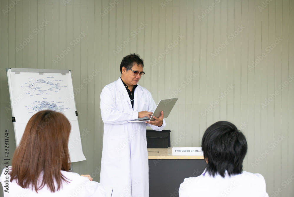 Professor hold the laptop while teaching about the fish anatomy to ...