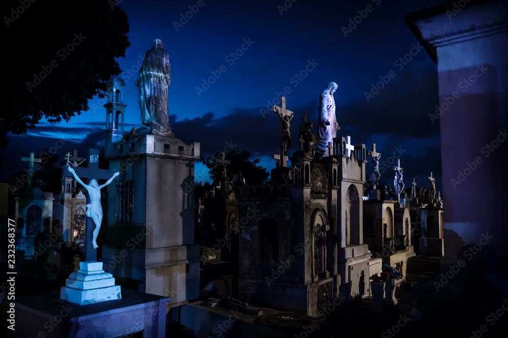 Jesus statues at dark blue lightened tombstones during dawn in ...