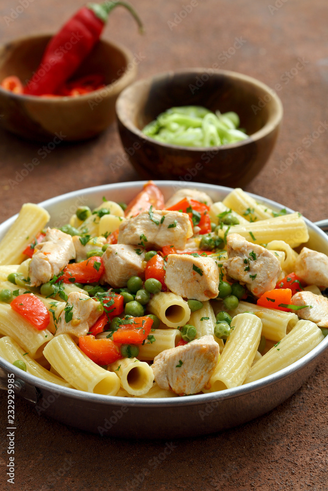 Pasta maccheroni con pollo piselli e verdure in padella di metallo ...