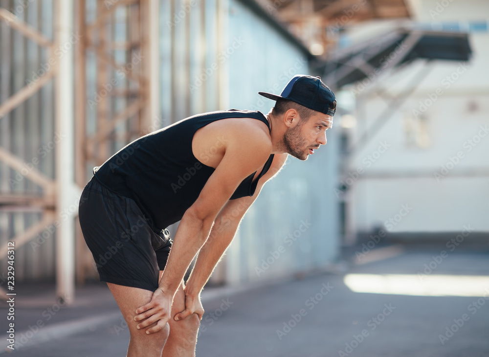 Tired man runner rest after running on city stree Stock Photo | Adobe Stock