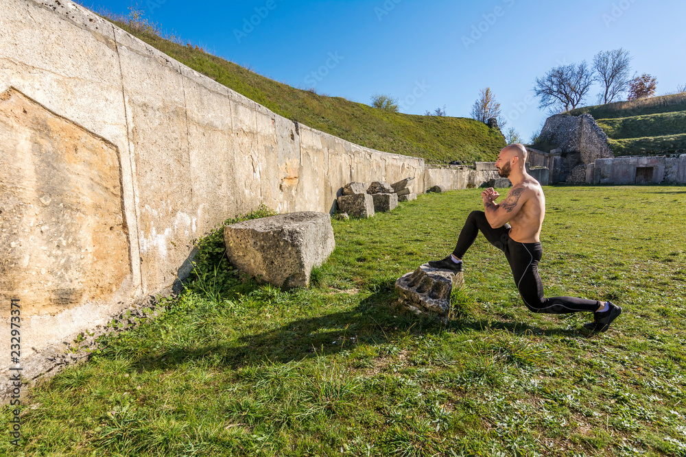 Handsome Body builder Man does phisical exercises outdoor. Innovative ...