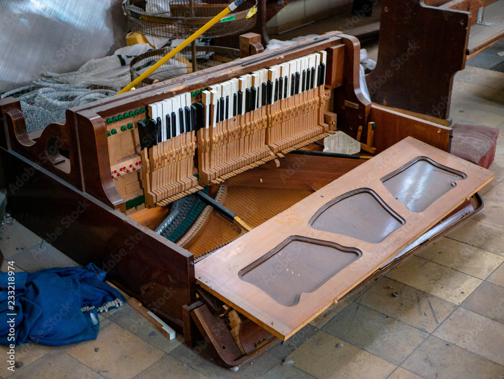 Old broken piano fallen over and destroyed by vandalism in an abandoned ...
