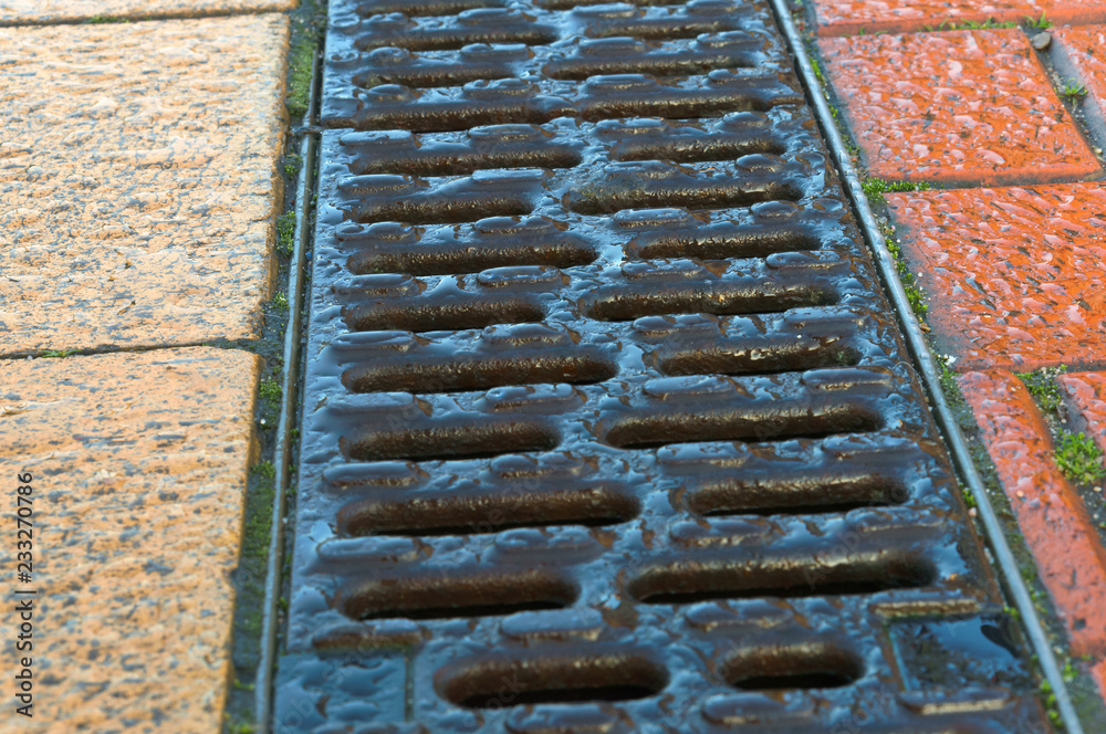 Sidewalk drainage. Grate - rain gutter on the sidewalk. Pathway paved ...