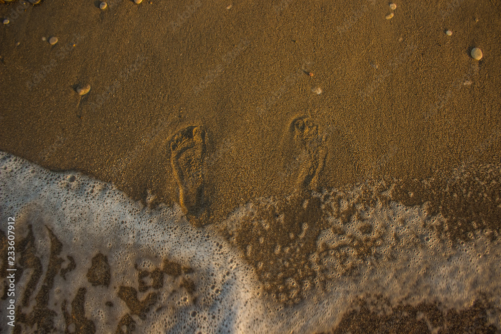 vacation concept design of human footprint on yellow sea shore sand ...