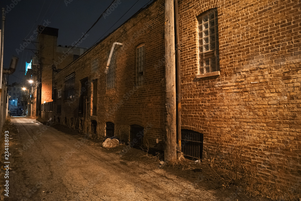 Dark and scary urban city alley with a vintage brick a wall at night ...