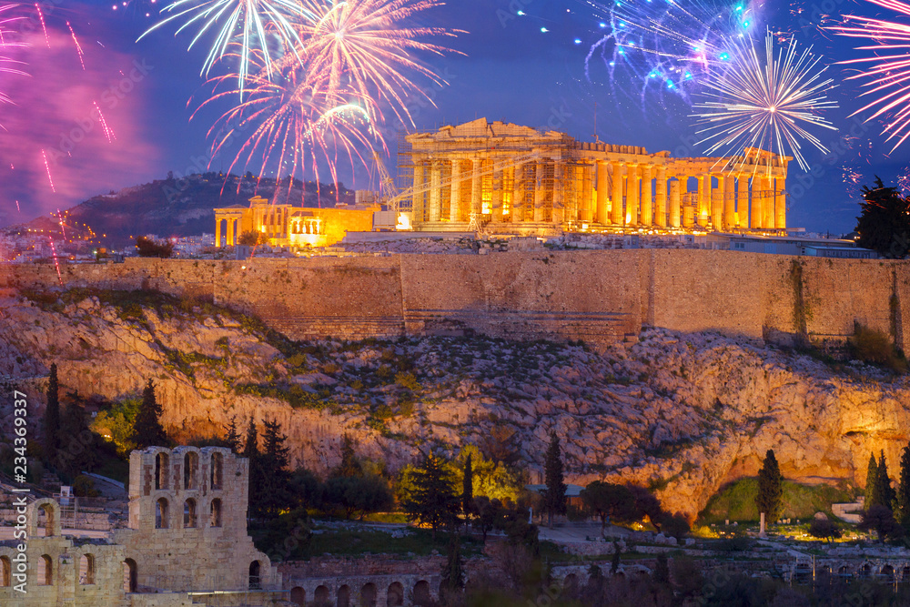 Famous skyline of Athens with Acropolis hill and Pathenon illuminated at night with fireworks ...